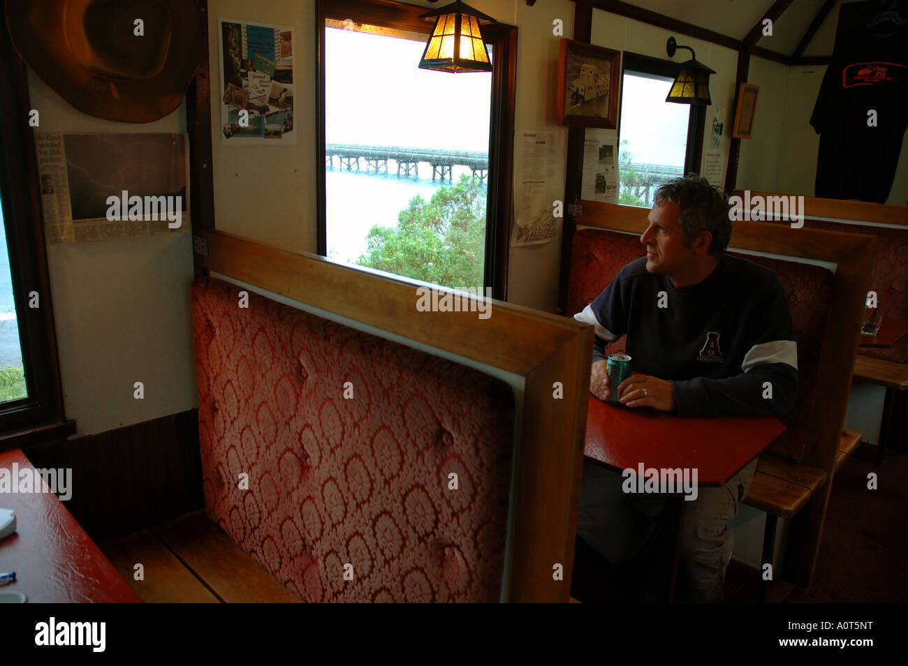 Man alone in booth at the Cray Pot diner end of the road at Jackson Bay ...