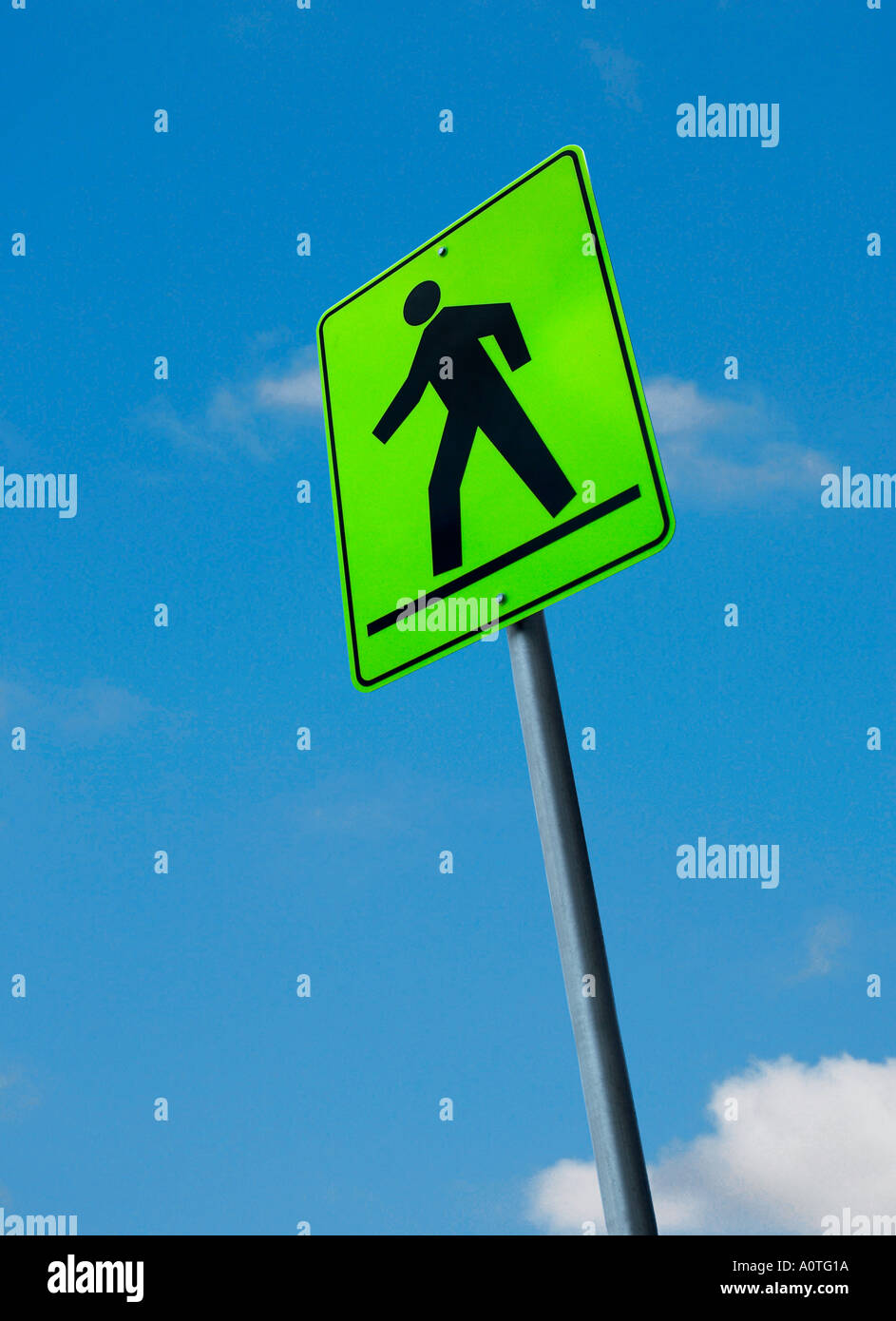 Green pedestrian crossing or walkway road sign with a blue sky ...