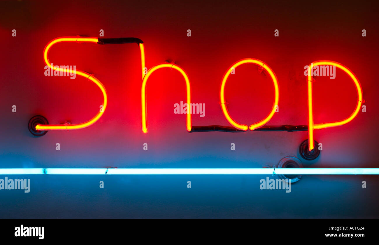 A glowing red and blue neon store sign with text spelling out Shop ...