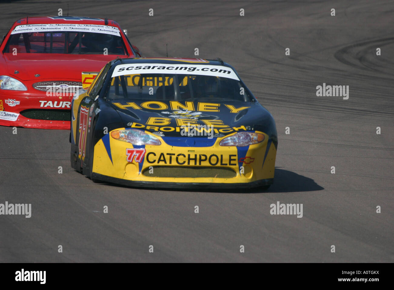 V8 Nascar type stock cars racing on a banked oval circuit Stock Photo ...