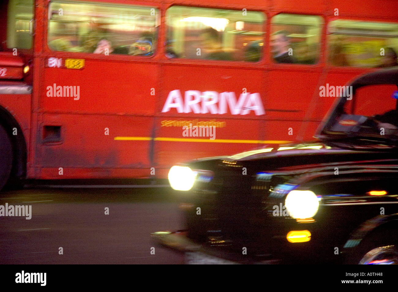 Red double decker bus whizzing through Piccadilly Circus in London ...