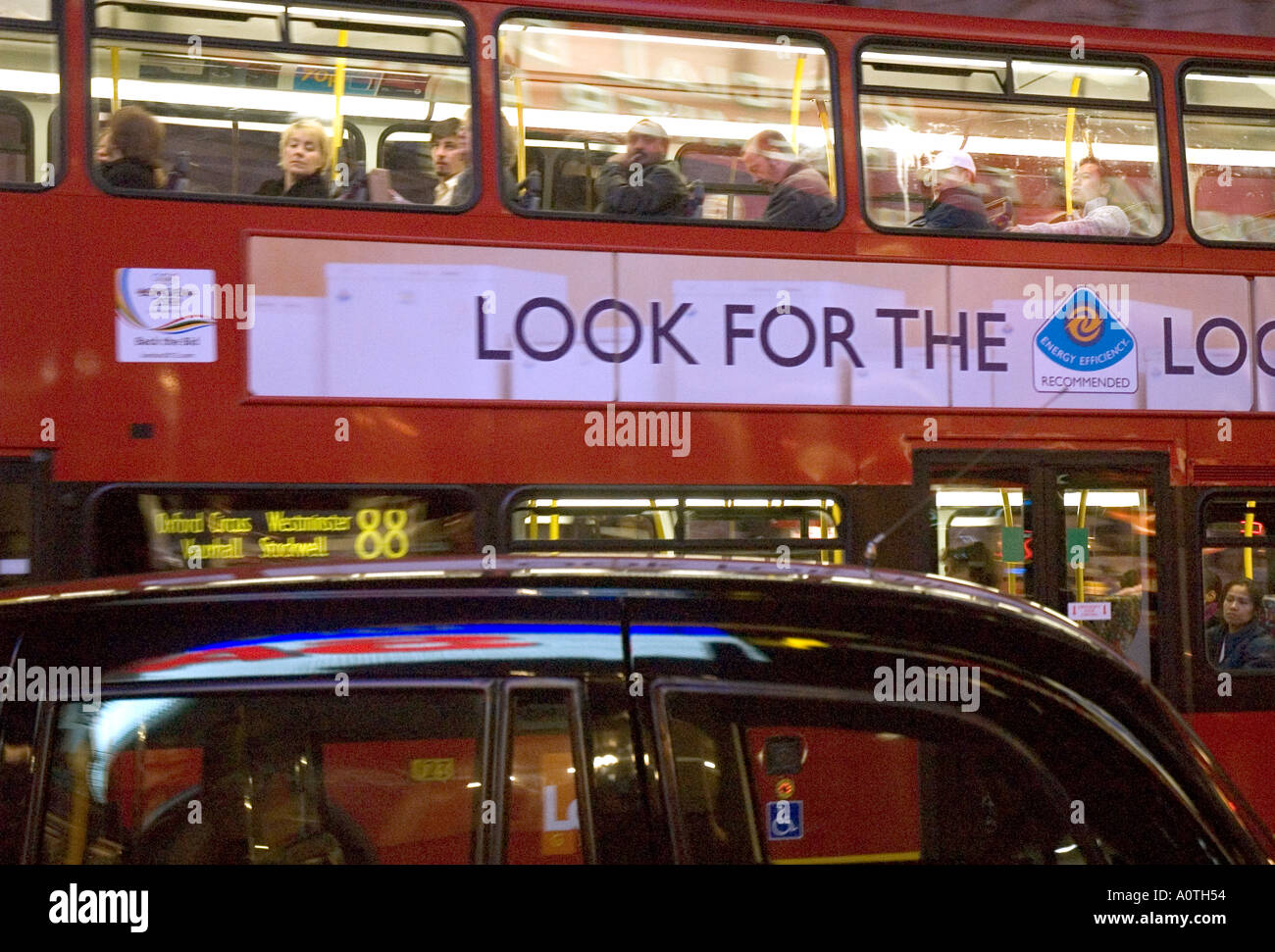 Red double decker bus whizzing through Piccadilly Circus in London ...