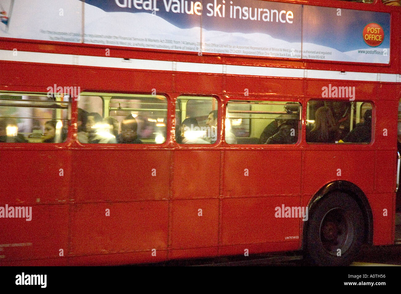 Red double decker bus whizzing through Piccadilly Circus in London ...