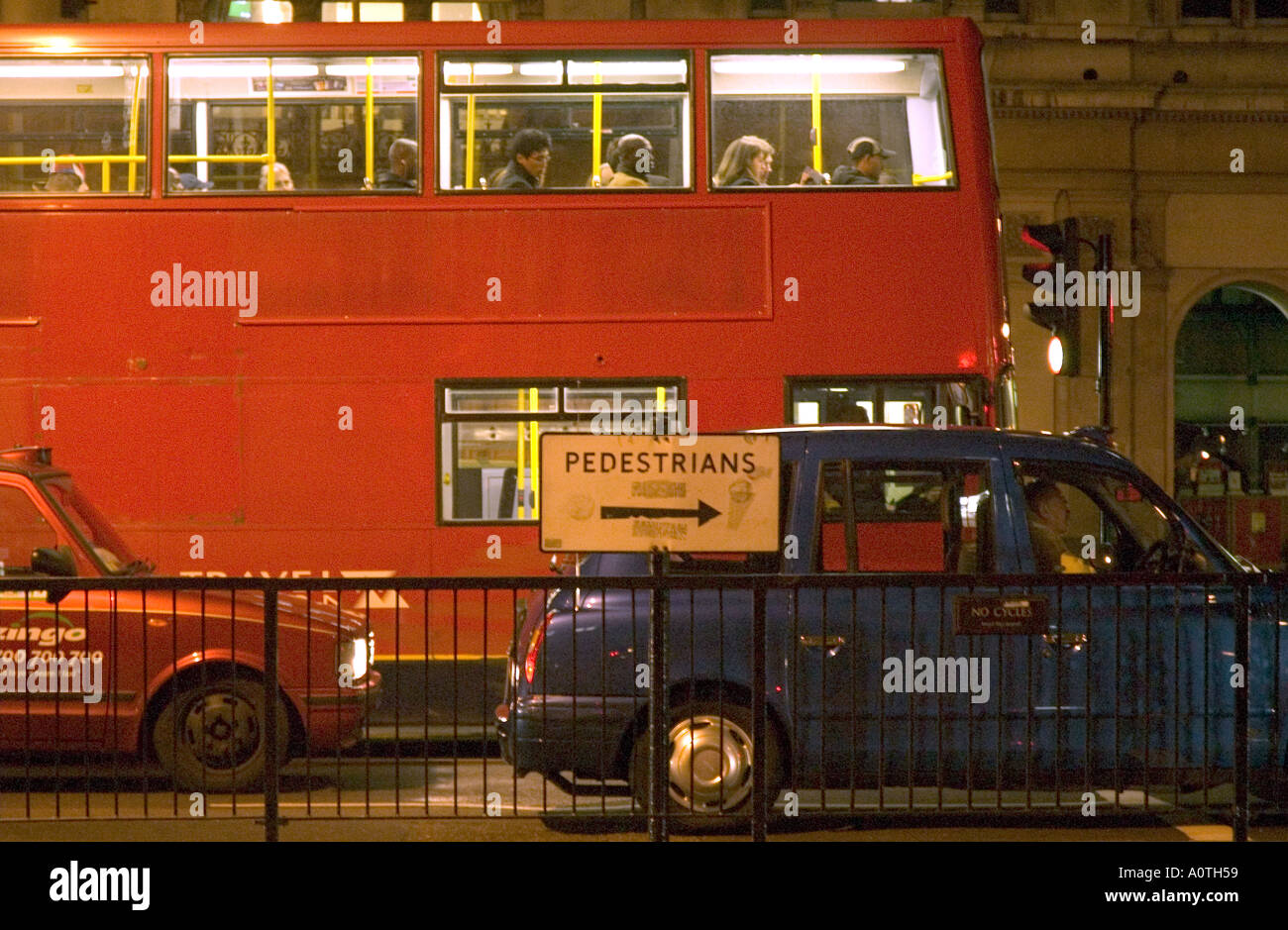 Red double decker bus whizzing through Piccadilly Circus in London ...