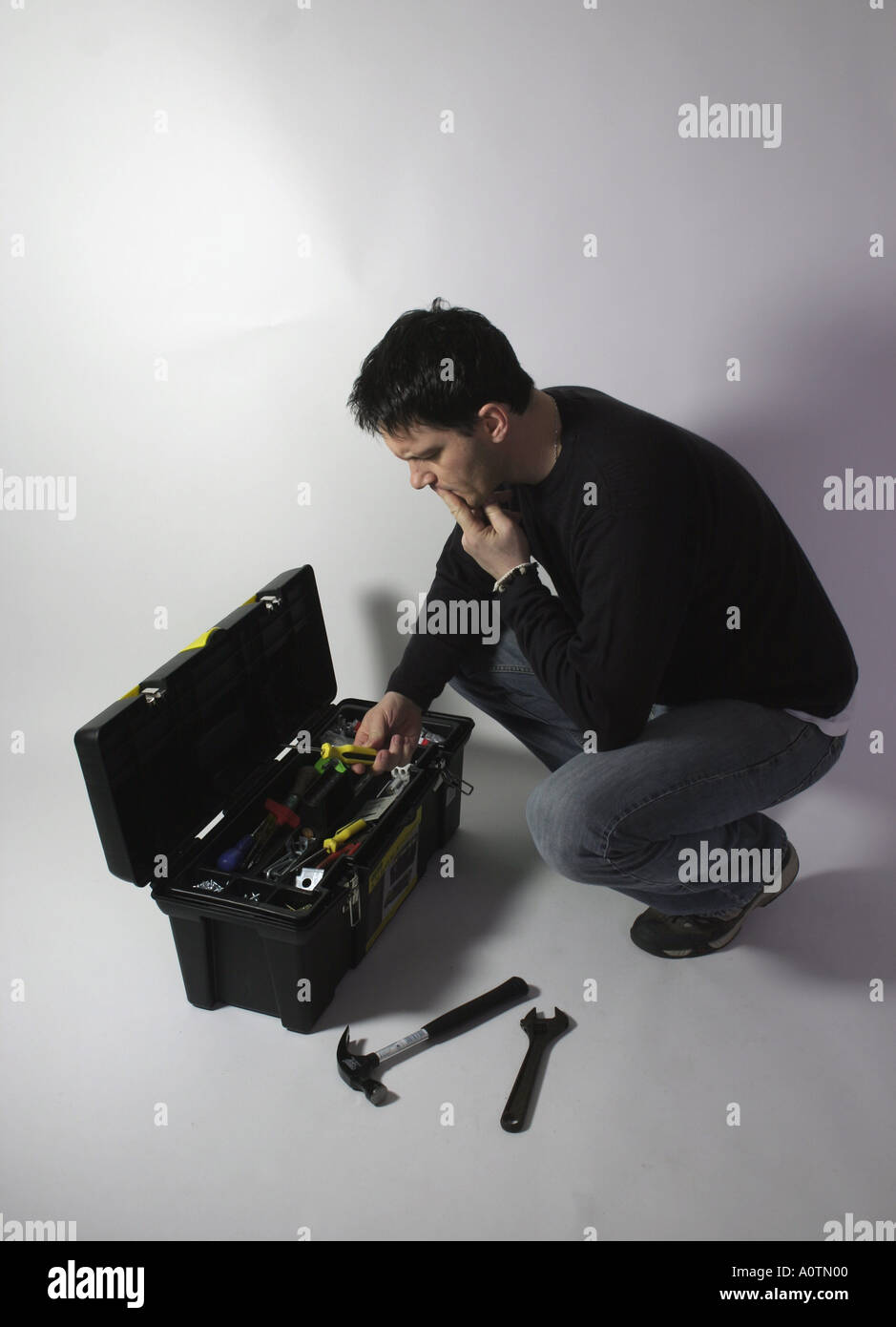 Man in casual clothes makes his choice of tool from the toolbox Stock ...
