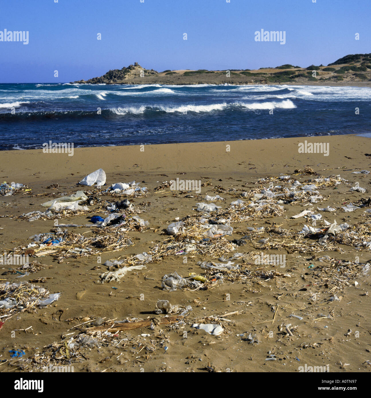 Looking across a beach on north coast with polluted sands covered in ...