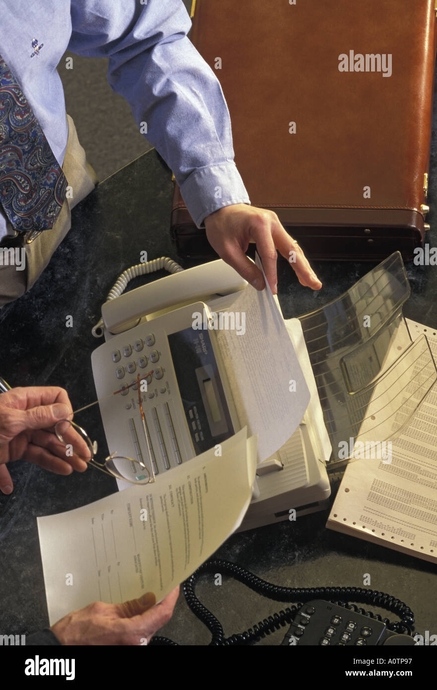 Caucasian corporate executive faxing documents Stock Photo - Alamy