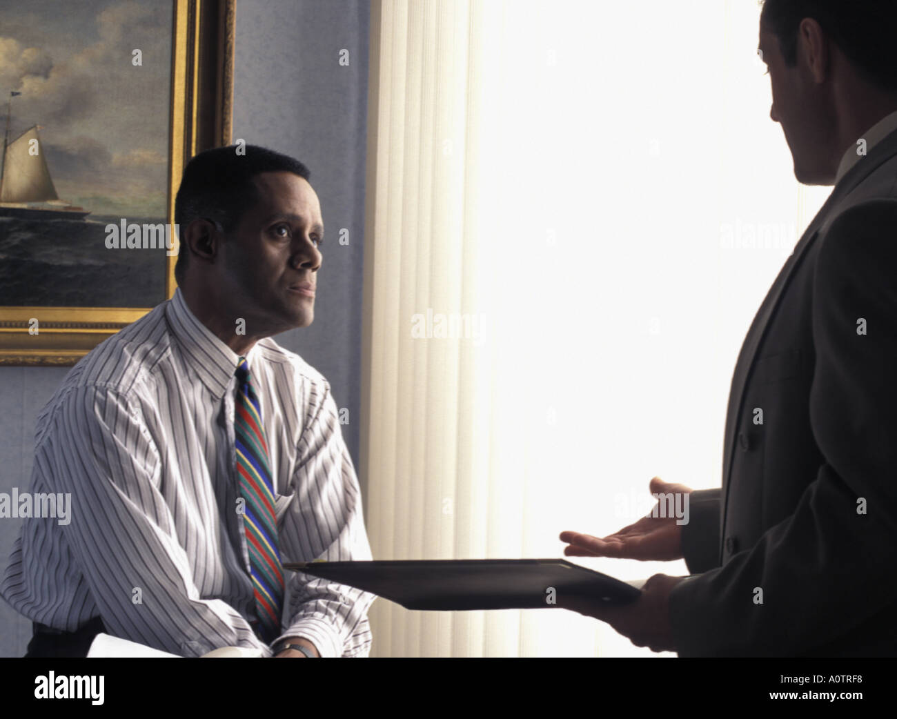 Business discussion between an African-American and Caucasian ...
