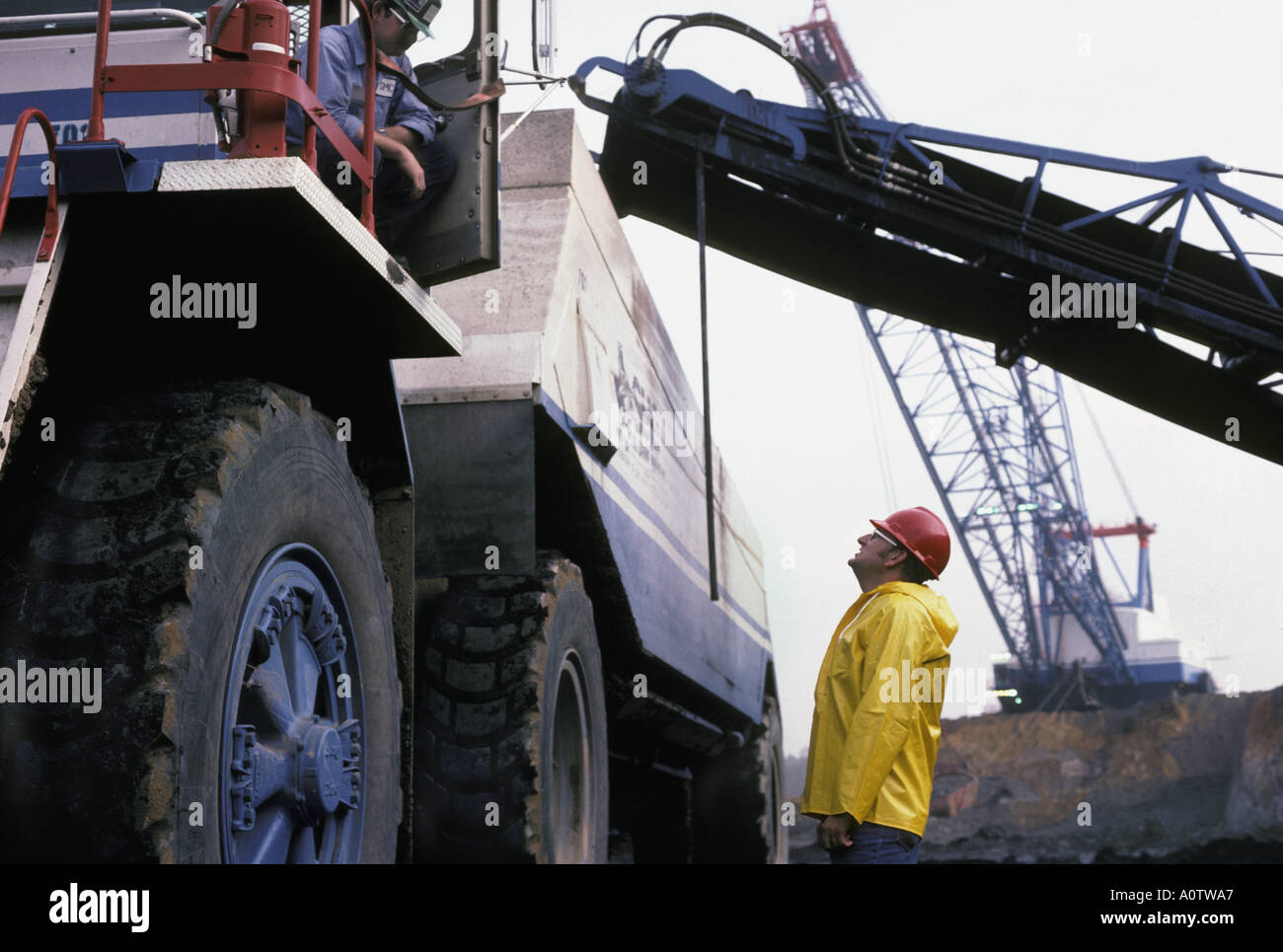 Huge coal haul truck and enormous electric dragline shovel and conveyor ...