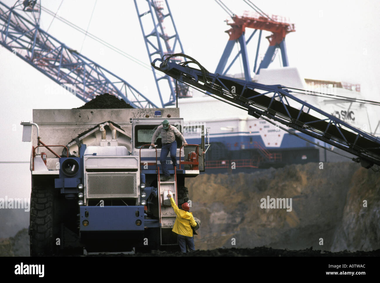 Huge coal haul truck and enormous electric dragline shovel and conveyor ...