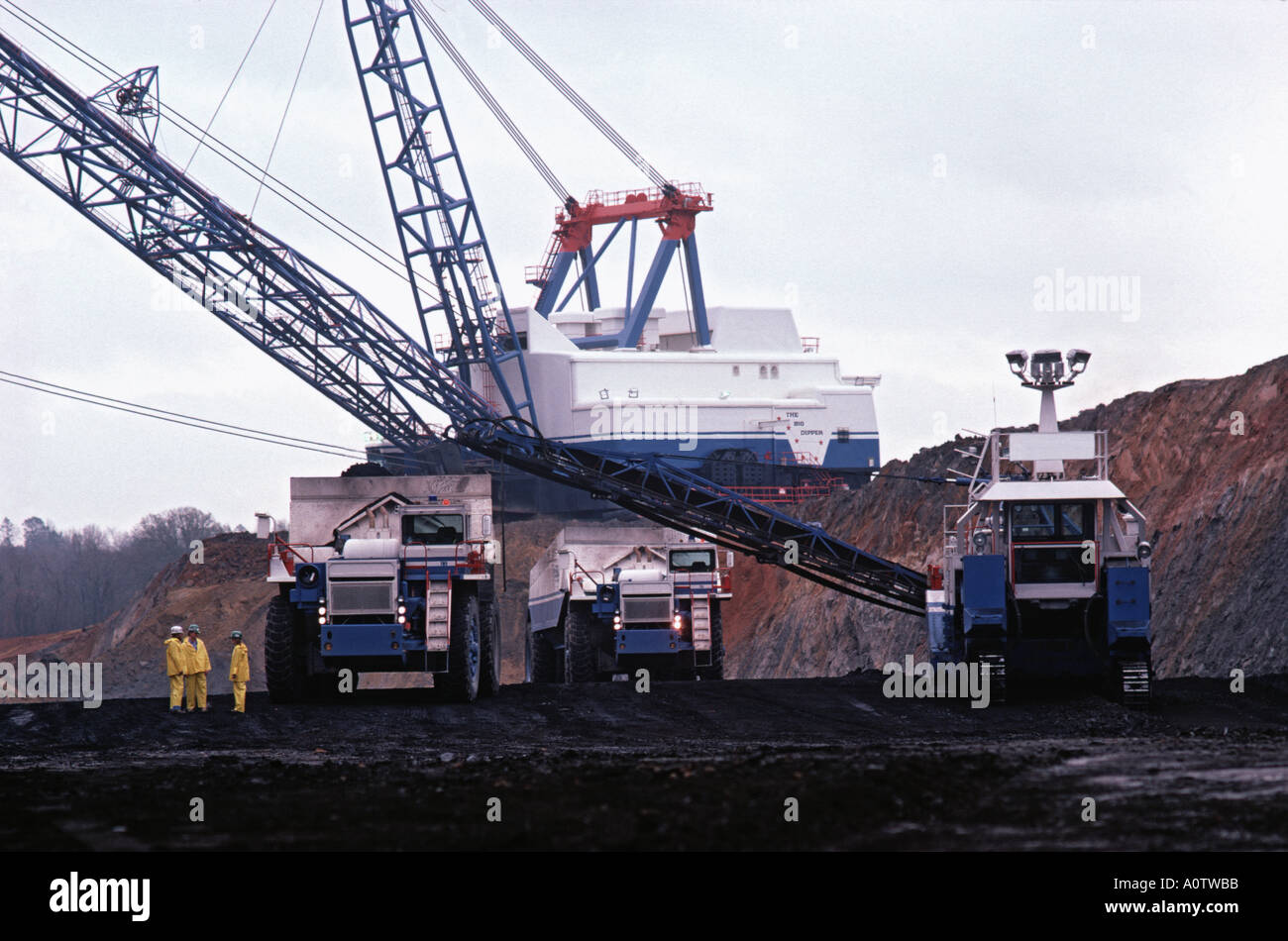enormous electric dragline shovel and haul trucks dwarfing three ...