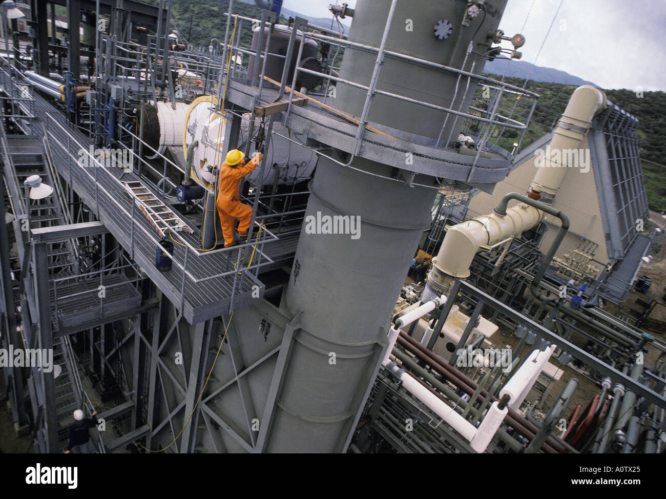 Workman climbing ladder to tower at power cogeneration plant Stock ...