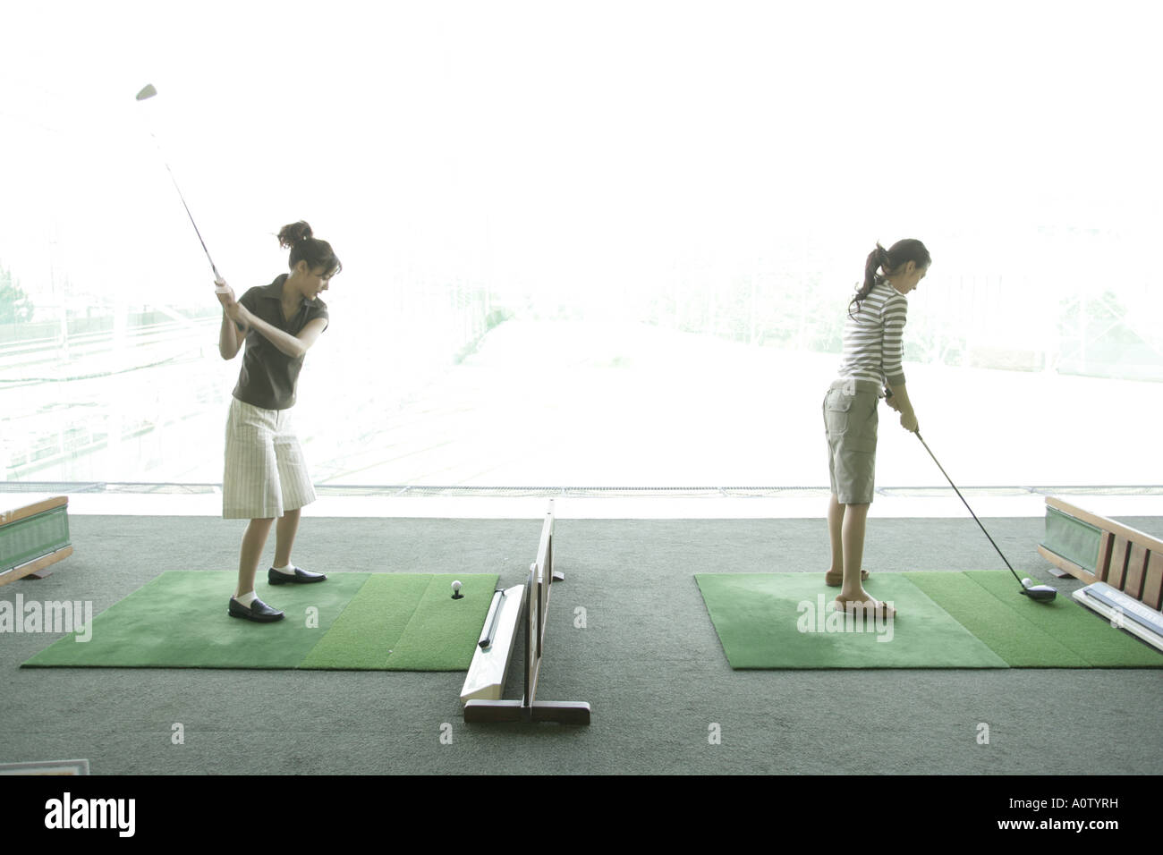 Two young women playing golf Stock Photo - Alamy