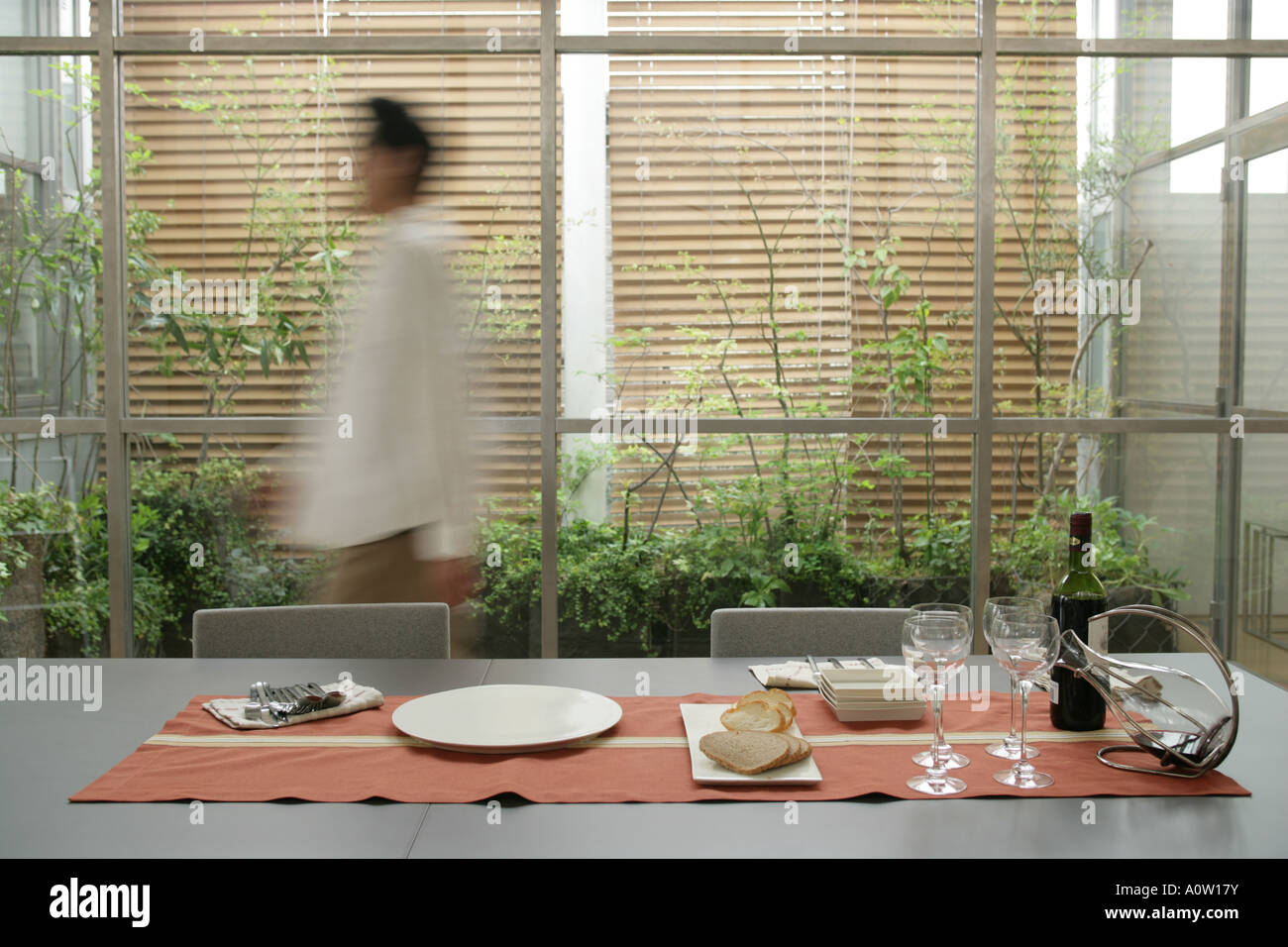 Side profile of a person walking near a dining table Stock Photo - Alamy