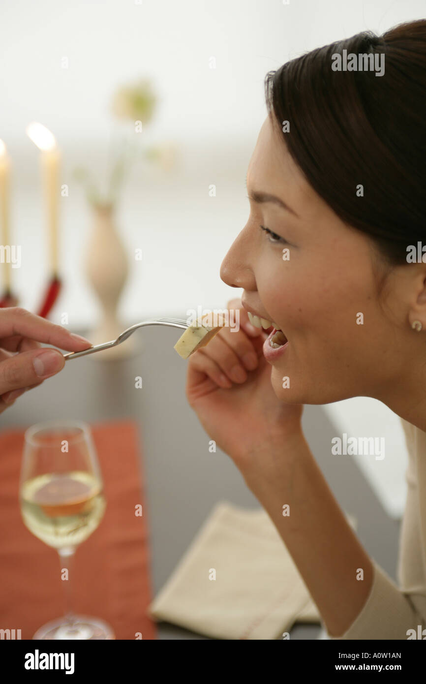 Close up of a person giving a piece of cheese to a young woman Stock ...