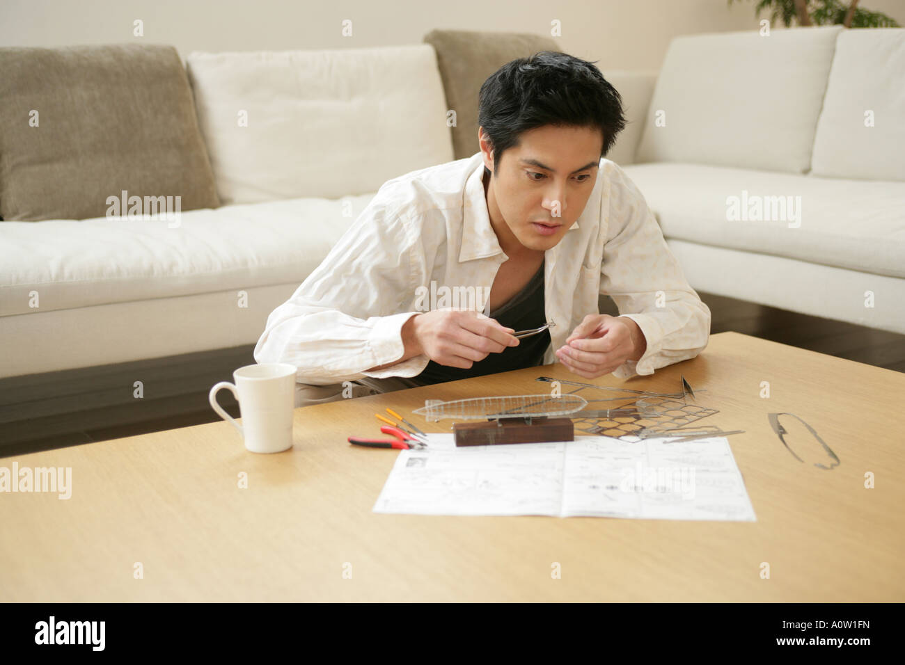 Young man assembling a model of an airship Stock Photo - Alamy