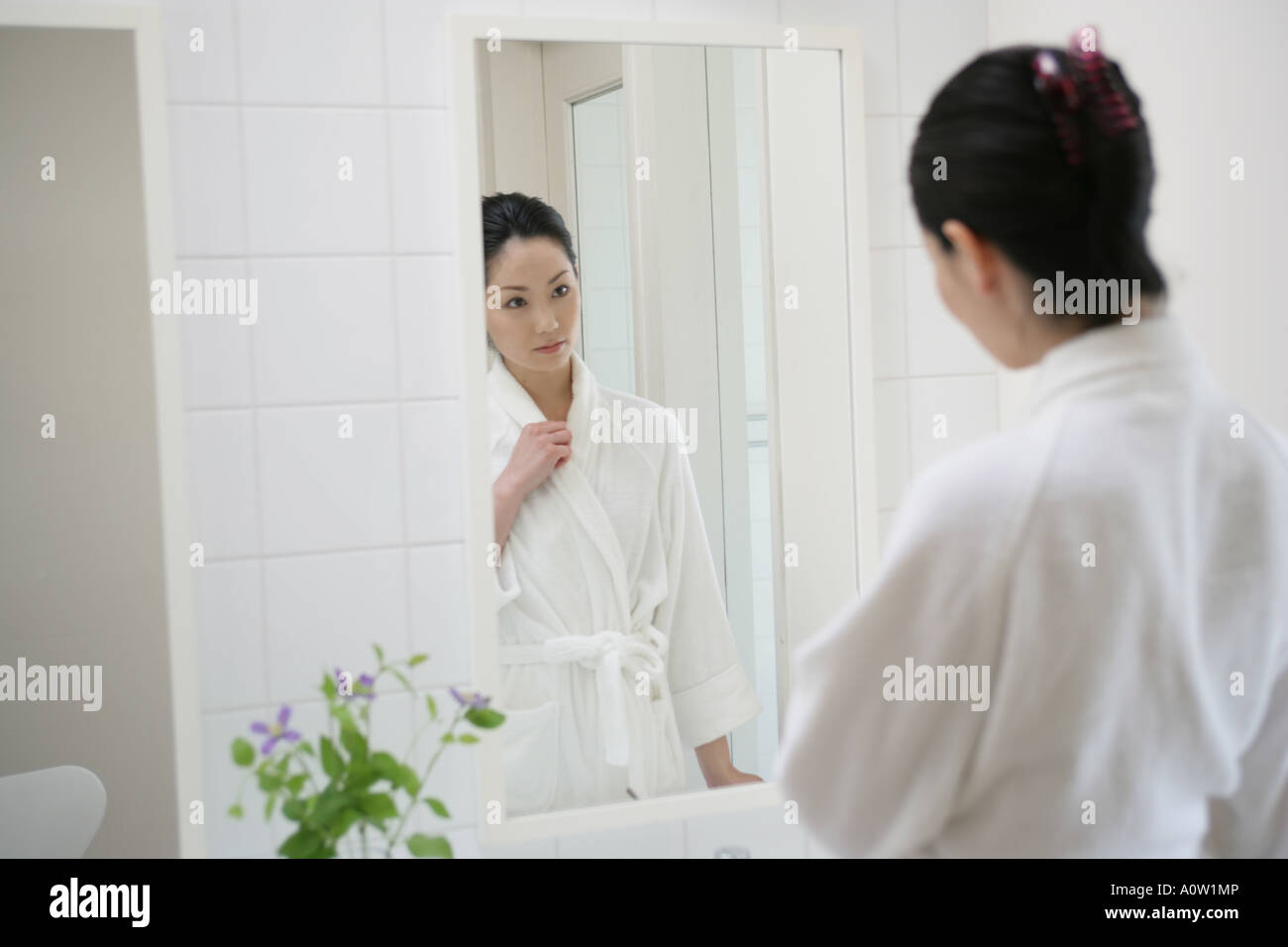 Rear view of a young woman in front of a mirror Stock Photo - Alamy