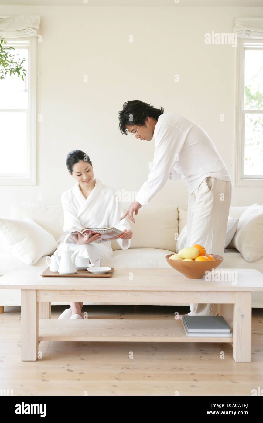 Young man pointing towards a magazine held by a young woman Stock Photo ...
