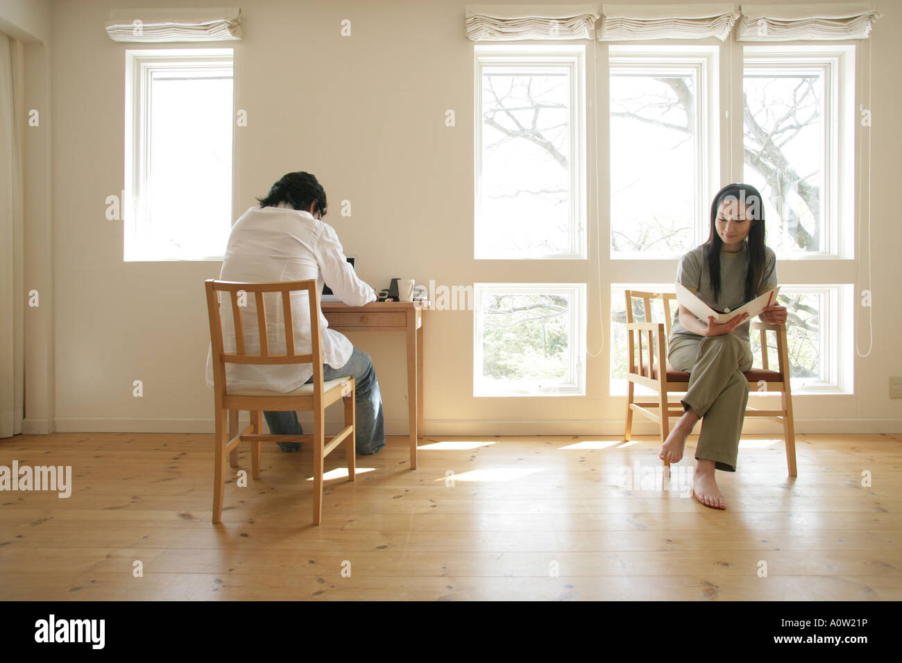Young couple sitting on chairs Stock Photo - Alamy