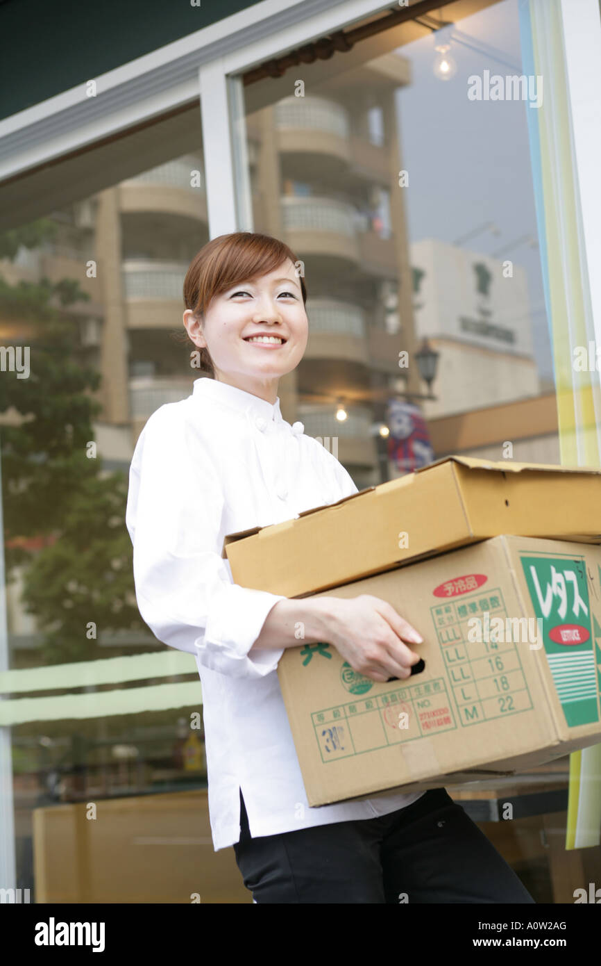 Female chef carrying cardboard boxes Stock Photo - Alamy