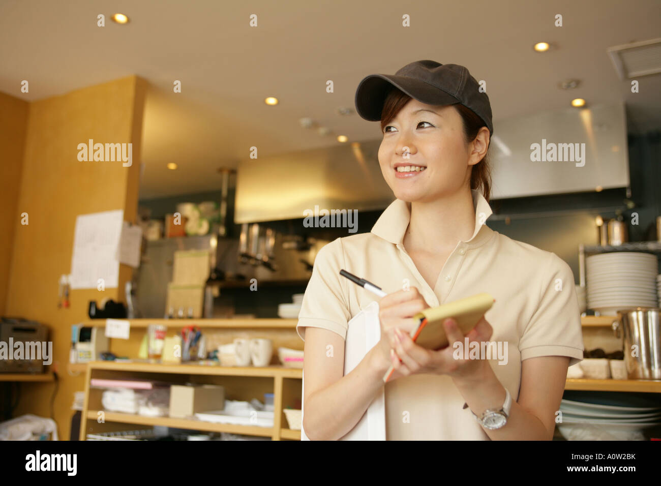 Close up of a waitress writing on a notepad and smiling Stock Photo - Alamy