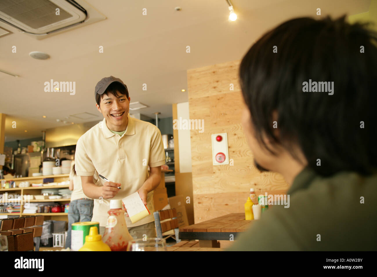 Waiter taking an order from a customer and smiling Stock Photo - Alamy