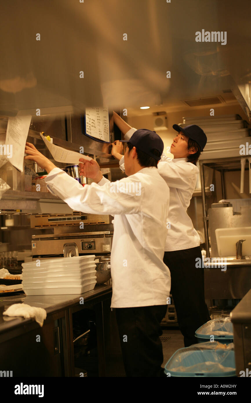 Side profile of two waiters standing in the kitchen Stock Photo - Alamy