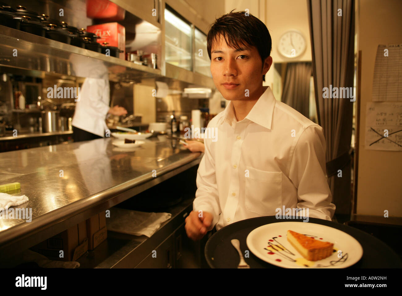 Portrait of a waiter holding a plate of food in the kitchen Stock Photo ...