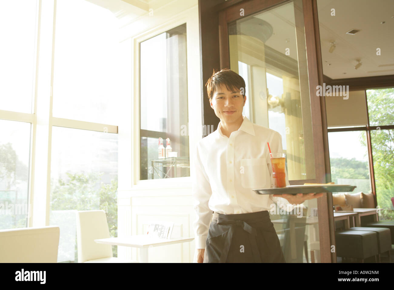 Portrait of a waiter standing and holding a tray Stock Photo - Alamy