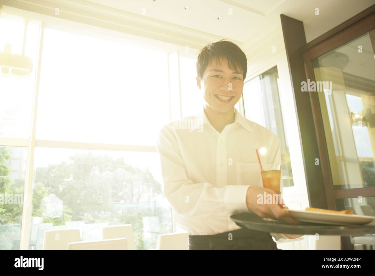 Portrait of a waiter standing and holding a tray Stock Photo - Alamy
