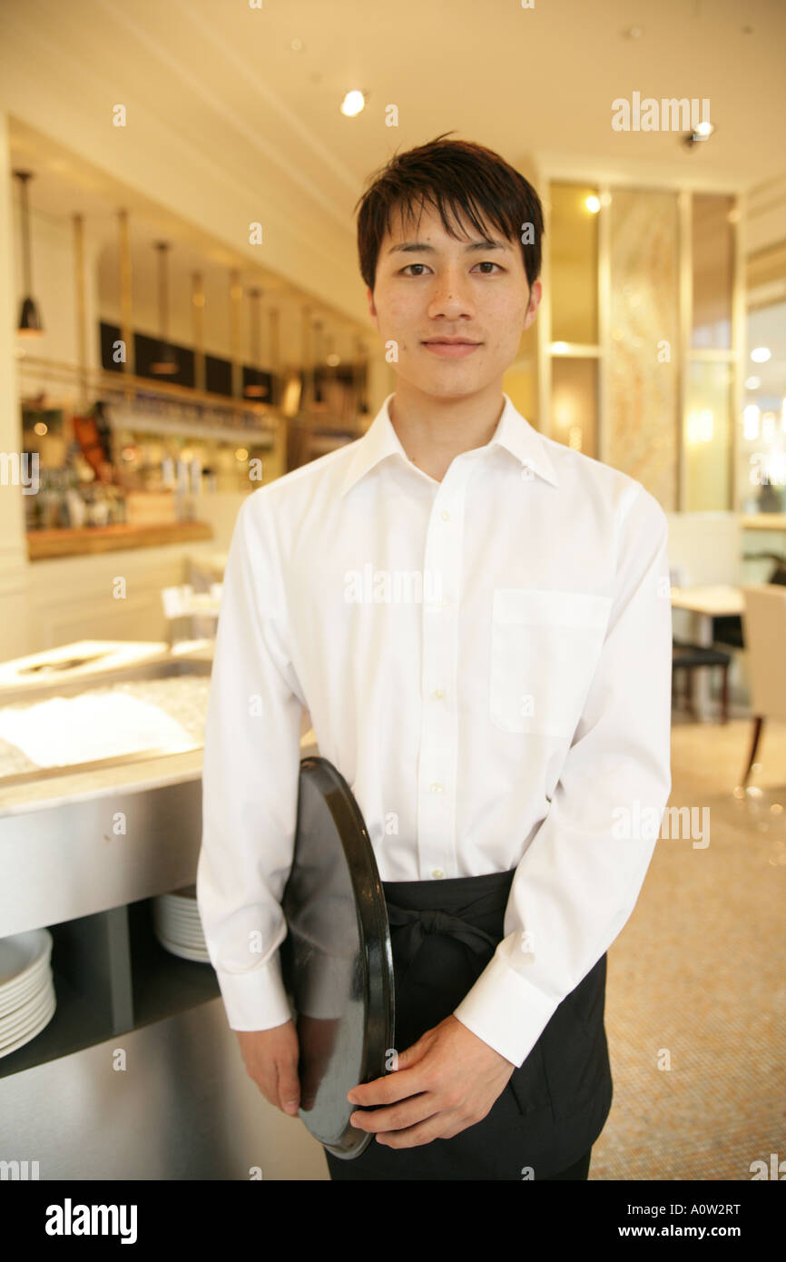 Portrait of a waiter standing and holding a tray Stock Photo - Alamy