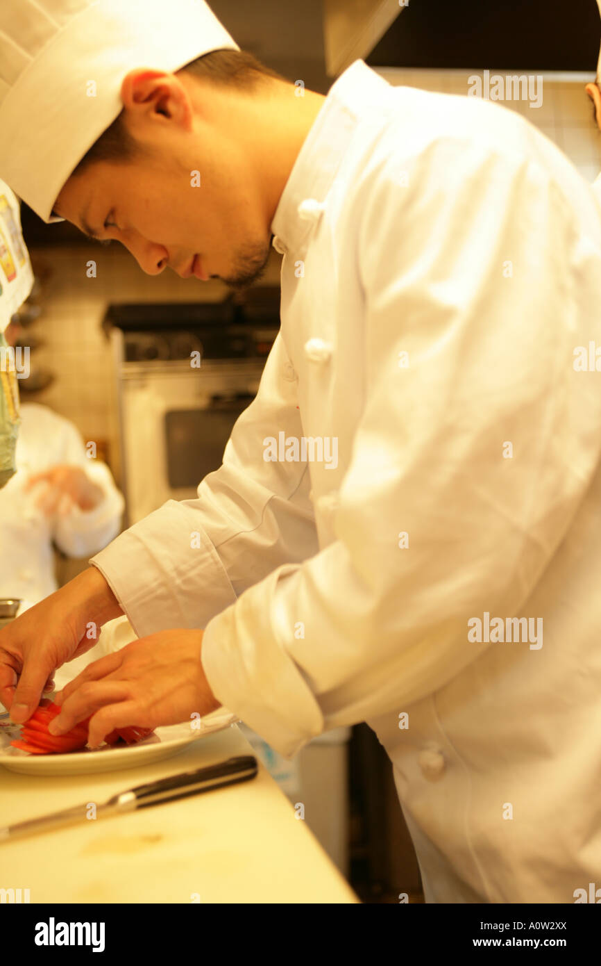 Side profile of a male chef arranging tomato slices in a plate Stock ...