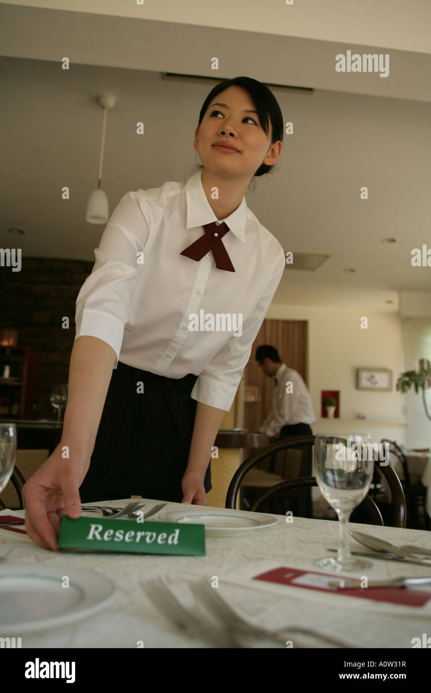 Close up of a waitress putting a reserved sign on the table Stock Photo ...