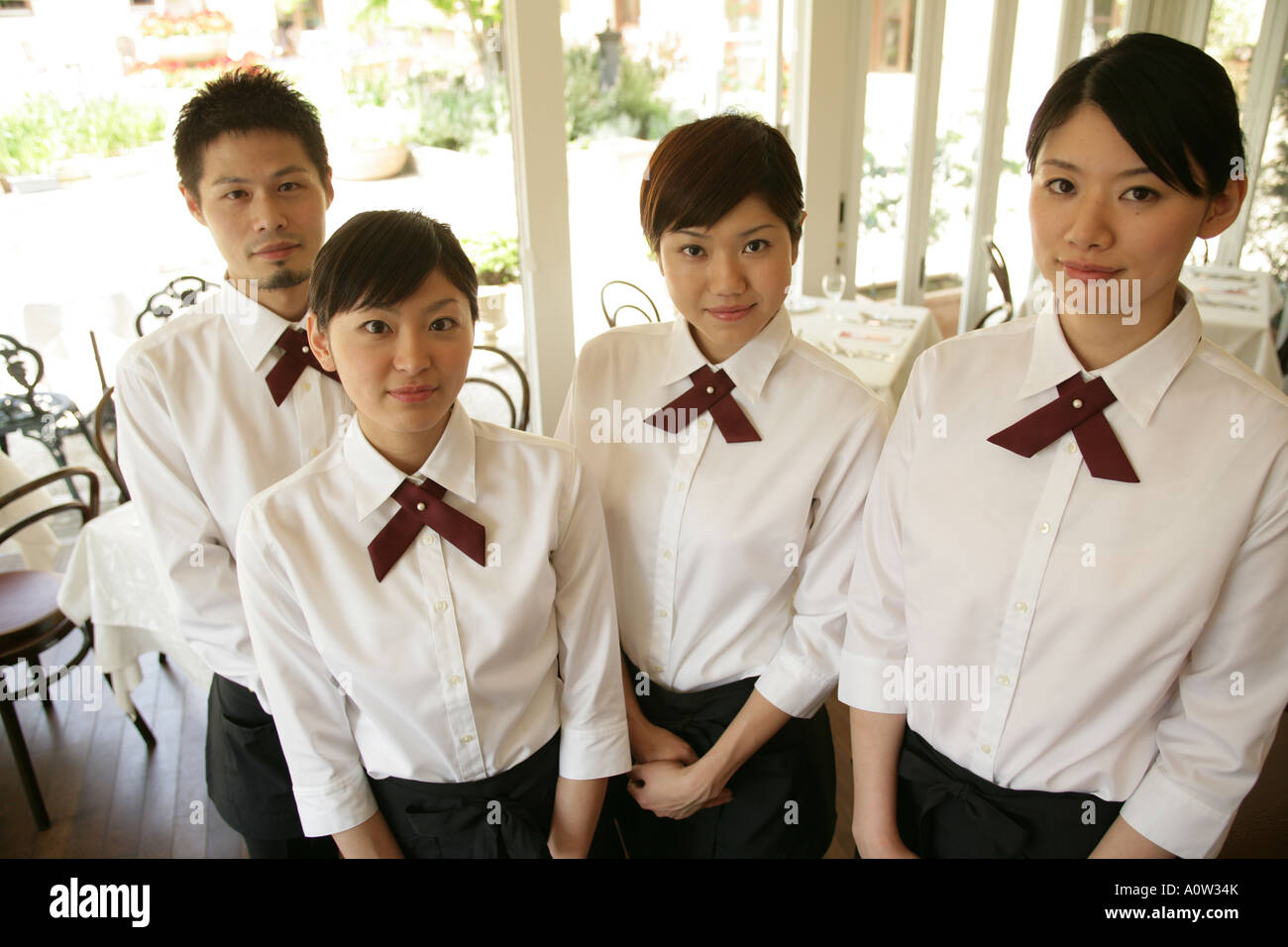 Portrait of three waitresses and a waiter Stock Photo - Alamy