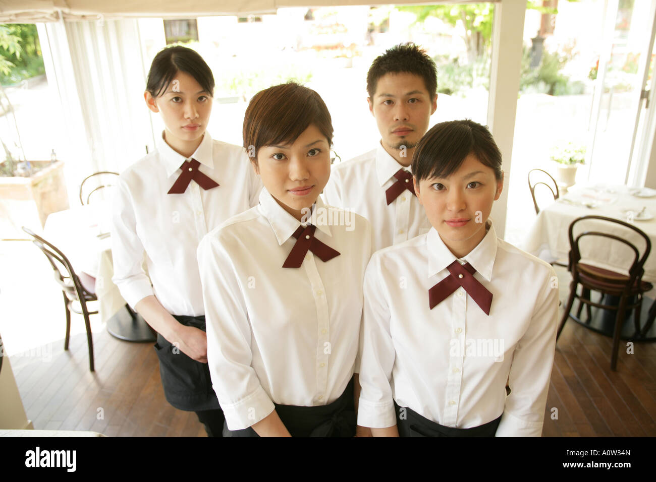 Portrait of a waiter and three waitresses Stock Photo - Alamy