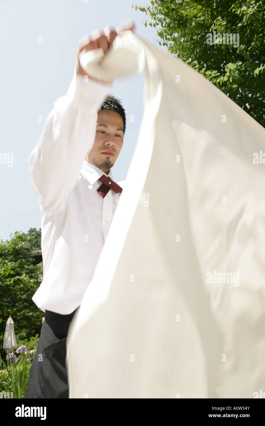 Waiter holding a tablecloth Stock Photo - Alamy