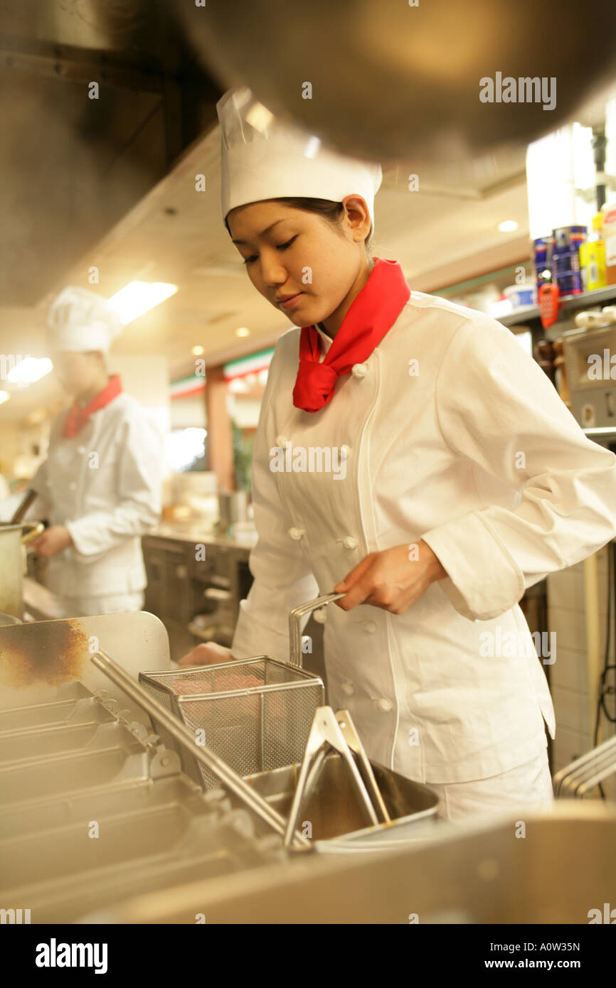 Female chef cooking food in the kitchen Stock Photo - Alamy
