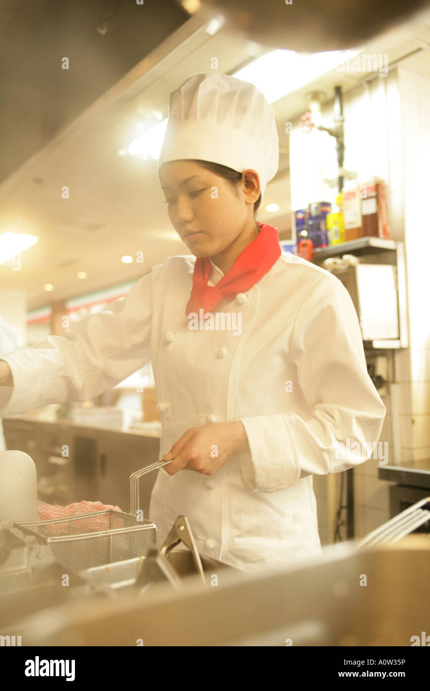 Female chef cooking food in the kitchen Stock Photo - Alamy