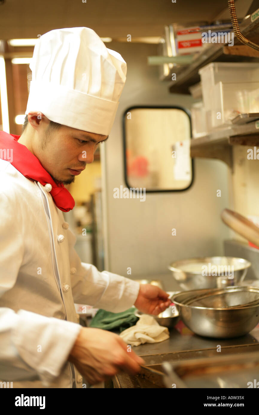 Side profile of a chef preparing food in the kitchen Stock Photo - Alamy