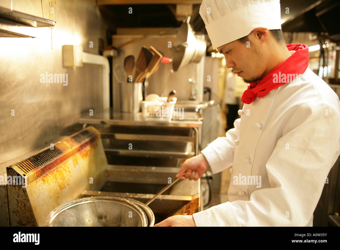 Side profile of a chef preparing food in the kitchen Stock Photo - Alamy