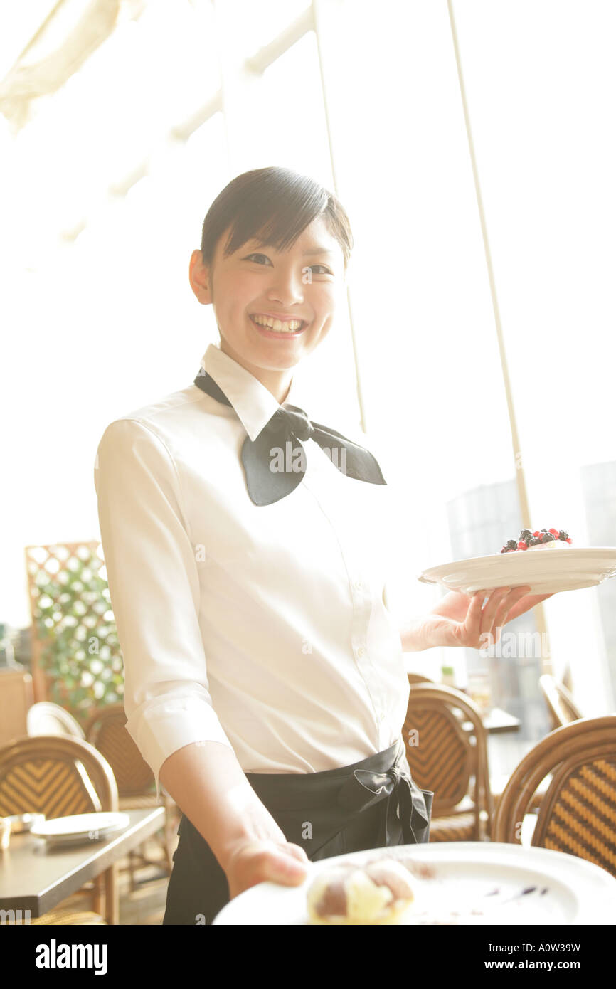 Portrait of a waitress serving food on the table Stock Photo - Alamy