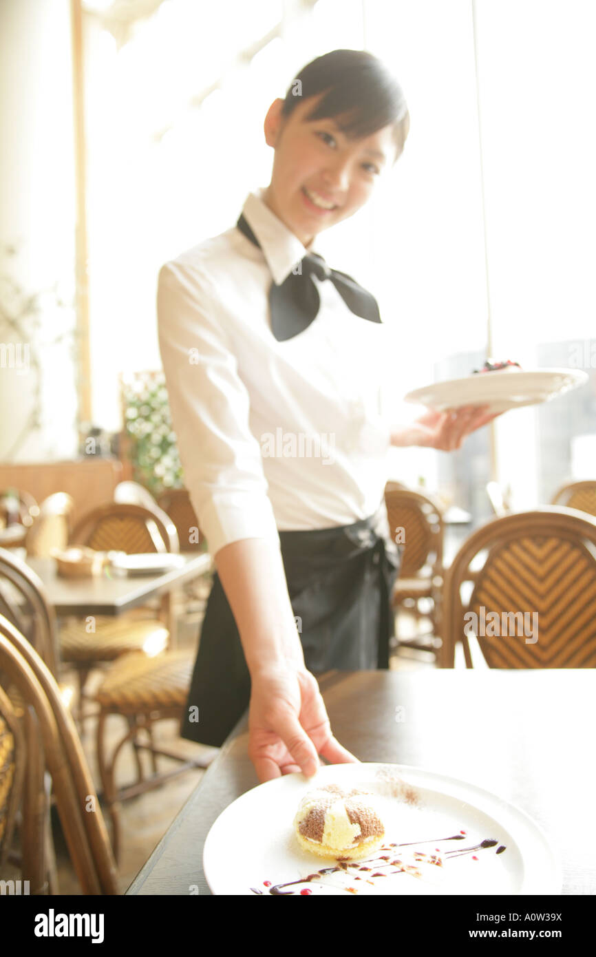 Portrait of a waitress serving food on the table Stock Photo - Alamy