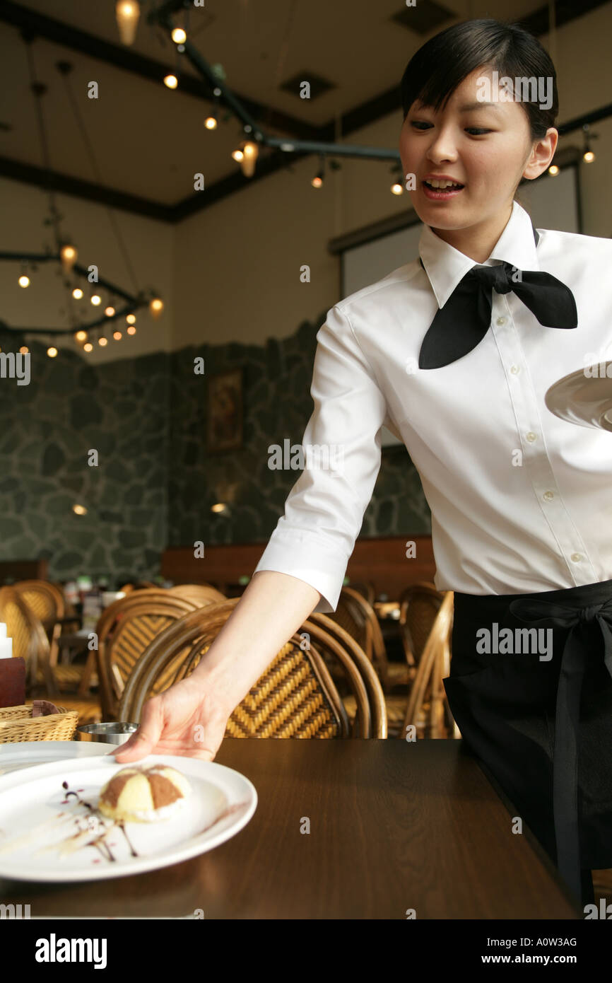 Close up of a waitress serving food on the table Stock Photo - Alamy