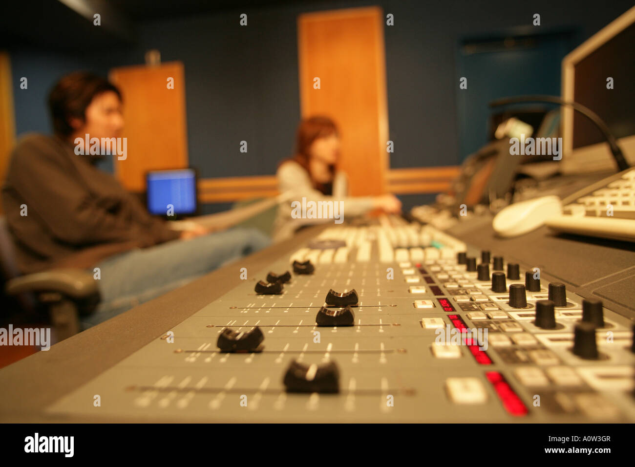 Young woman and a young man sitting in a recording studio Stock Photo ...
