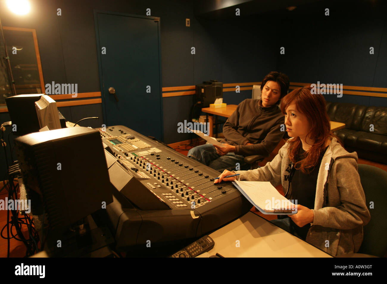 Young woman and a young man sitting in a recording studio Stock Photo ...