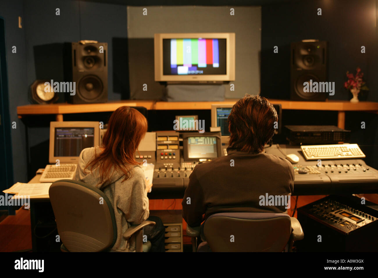 Rear view of a woman and a man sitting in a recording studio Stock ...