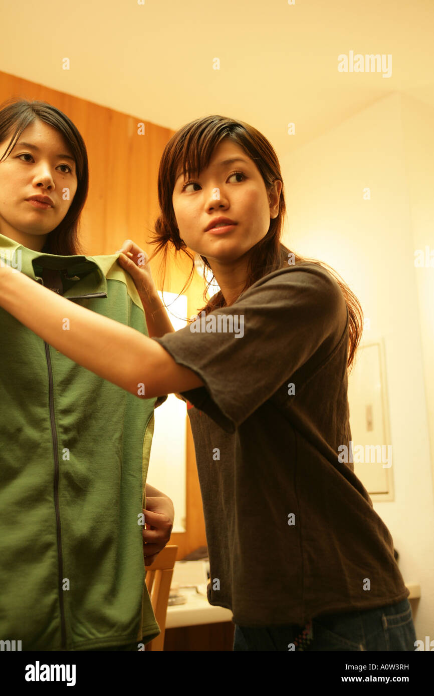 Fashion designer assisting female fashion try on jacket Stock Photo - Alamy