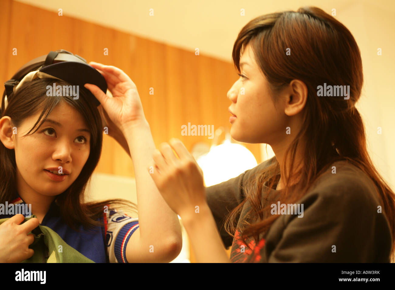 Close-up of fashion designer assisting female fashion model in dressing ...