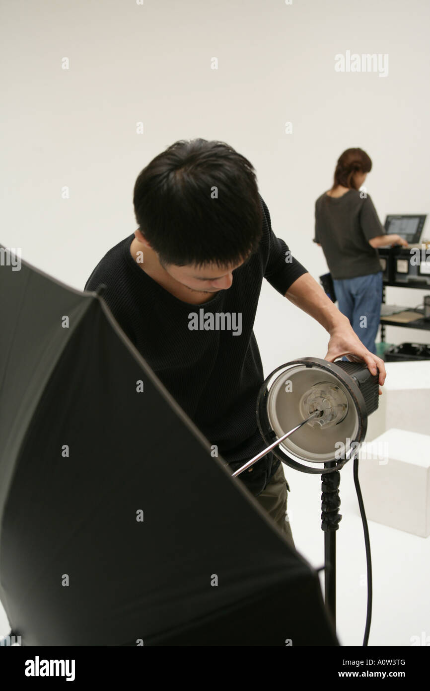 Close up of a young man adjusting lighting equipment in a film studio ...