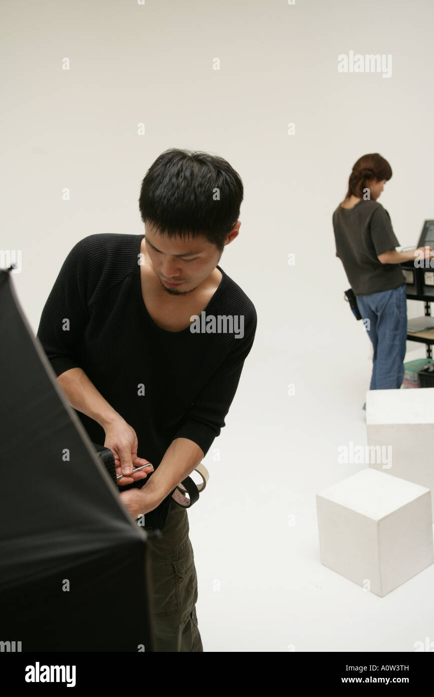 Close up of a young man adjusting lighting equipment in a film studio ...